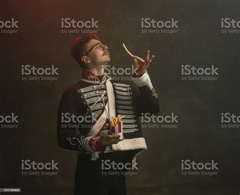 어두운 녹색 배경에 고립 된 왕실 사람으로 양복을 입은 젊은 남자 복고풍 스타일 시대의 개념의 비교 역사적 인물 군주 구식과 같은 아름다운 남성 모델 18 19세에 대한