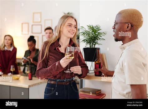 Happy Young Brunette Woman In Pink Pullover Clinking Flute Of Champagne