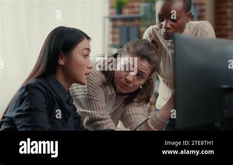 Software Engineer Pointing At Computer Screen Explaining Running Code To Coworkers Brainstorming