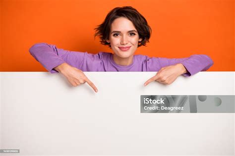 펑키 반짝이는 소녀의 사진 보라색 풀오버를 입고 흰색 플래 카드 빈 공간을 가리키는 고립 된 주황색 배경 보여주기에 대한 스톡 사진 및 기타 이미지 Istock