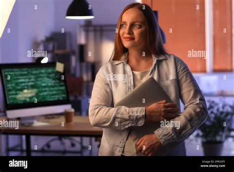 Female Programmer With Laptop In Office At Night Stock Photo Alamy