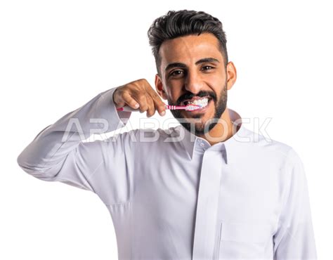 بورتريه بصورة مقربة لرجل عربي خليجي سعودي ، يقوم بتنظيف الأسنان بفرشاة