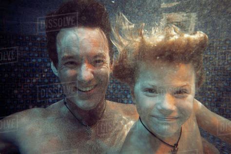 Father And Son Swimming Underwater In Swimming Pool Stock Photo Dissolve
