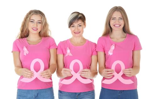 Hermosas mujeres sosteniendo símbolos de concienciación sobre el cáncer de mama sobre fondo