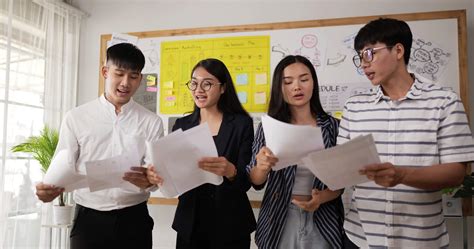 Four Business People Having An Argument While Standing In An Office Asian Man And Woman Holding