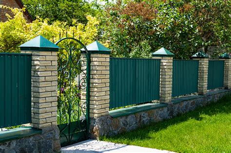 녹색 금속 골판지 울타리와 녹색 배경에 벽돌 기둥이 있는 문 0명에 대한 스톡 사진 및 기타 이미지 0명 강철 건설 프레임 Istock