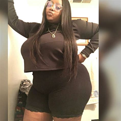 A Woman In Tight Black Shorts Is Posing For The Camera