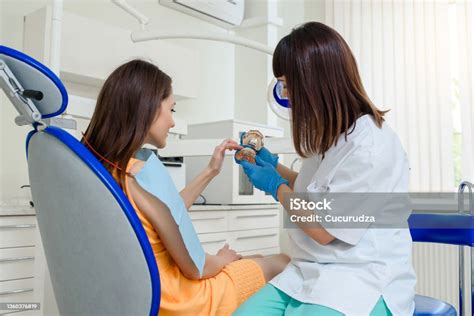 여자 치과 의사가 치아 상악 모델에 환자에게 미래 임플란트의 위치를 설명합니다 설명하기에 대한 스톡 사진 및 기타 이미지