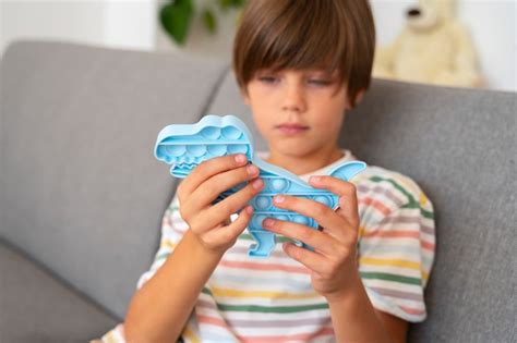 Menino Brincando Com Brinquedo Pop It Em Casa Foto Grátis