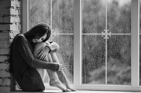 La Mujer Joven Hermosa Que Se Sienta Solamente Cerca De Ventana Con