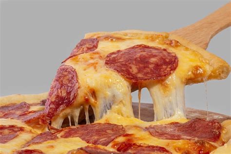 Rebanada De Pizza Con Pepperoni Y Queso Estirado Sobre Un Fondo Gris