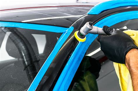 자동차 폴란드어 왁 스 작업자 연마 하기 전에 적용 보호 테이프를 손 버프 하 고 차를 연마입니다 자동차 적입니다 남자 손에서 폴 리 셔를 보유 하 고 차를 닦 Waxing