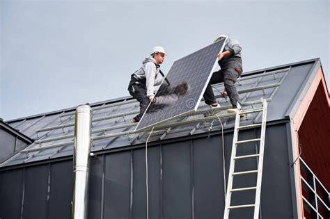 technicians carrying photovoltaic solar module while installing solar