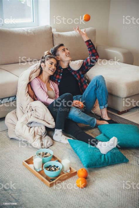 백인 사랑스러운 부부는 우유와 함께 시리얼을 먹는 격자 무늬로 덮여 바닥에 앉아있다 20 24세에 대한 스톡 사진 및 기타 이미지 20 24세 25 29세 2명