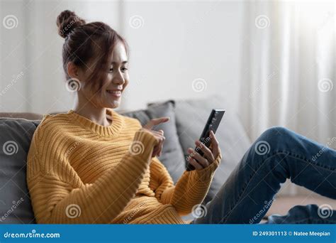 Happy Asian Teen Girl Checking Social Media Holding Smartphone At Home