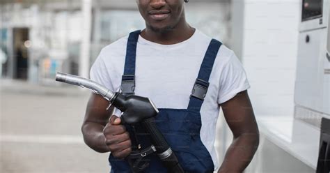 작업복을 입은 검은 피부의 남자 주유소 직원 주유소에서 야외에 서서 연료총 노즐을 손에 들고 있는 자른 이미지를 닫습니다 사진 Unsplash의 급 유 이미지