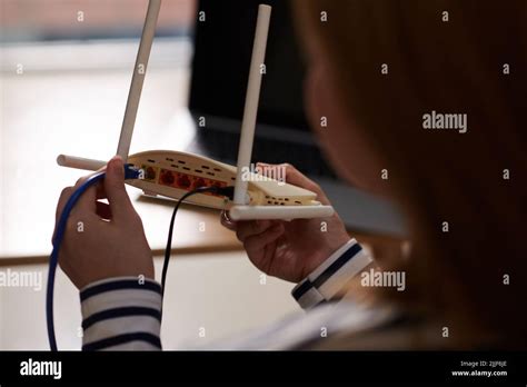 Woman Plugging Cord In Wi Fi Router To Get Internet Access Stock Photo Alamy