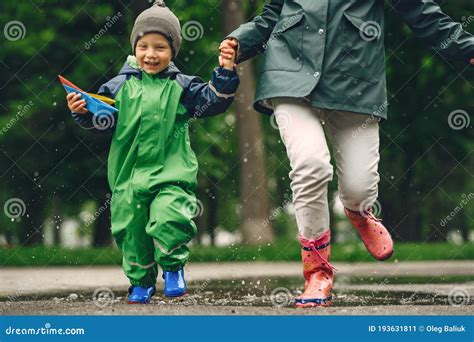 Grappige Jongen In Regenlaarzen Die Spelen In Een Regenpark Stock