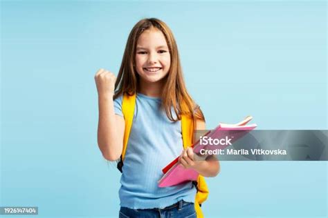 미소 짓는 쾌활한 귀여운 어린 소녀 배낭을 입고 책을 들고 승리 표시를 보여주는 몸짓 아이에 대한 스톡 사진 및 기타 이미지 아이 학생 행복 Istock