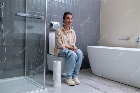 Premium Photo A Young Woman Sitting On A Toilet Bowl