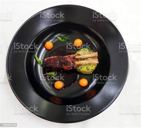 허리 양고기에 감자와 시금치의 메달 주변 노란 체리 토마토입니다 두껍게 자른 고깃점에 대한 스톡 사진 및 기타 이미지 두껍게