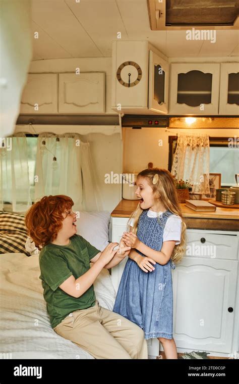Amazed Brother And Sister Looking At Each Other In Cozy Environment Of Trailer Home Happy