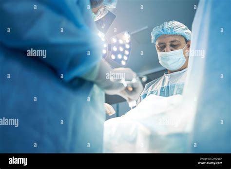 Concentrated Surgeon Working On Abdomen Operation In Surgery Room Stock