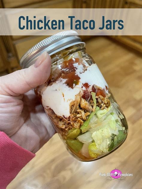 A Person Holding A Mason Jar Filled With Chicken Taco Jars