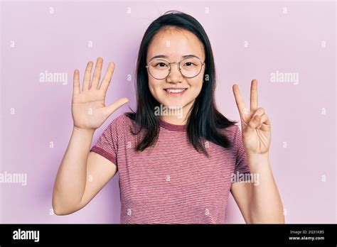 Young Chinese Girl Wearing Casual Clothes And Glasses Showing And