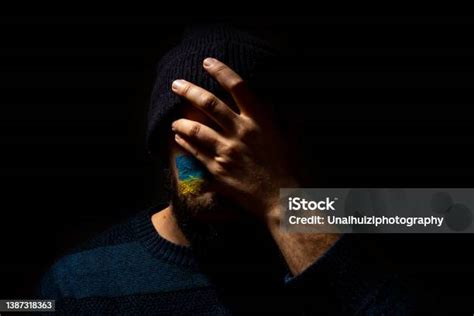 전쟁을 중지 우크라이나와 러시아 사이의 충돌 파란색과 노란색 깃발의 색상에 그려진 그의 얼굴을 가진 젊은 우크라이나어 검은 색 배경 매우 슬픈 Revolution에 대한