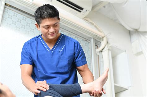 Asian Chiropractor Giving Leg Massage And Asian Woman Receiving