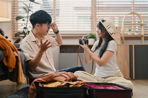 Happy Asian Couple Preparing For Honeymoon Vacation Packing Clothes Into Suitcase Stock Image