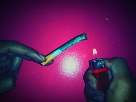 Premium Photo Cropped Hand Igniting Cigarette Against Pink Background