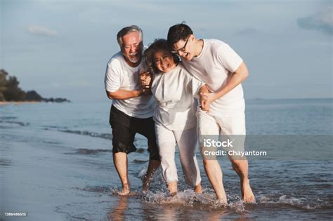 아시아 의 노인 부부와 아들이 여름 해변 일몰에 걷고 있습니다 휴가 와 여름 개념에 은퇴 후 여행 레저 및 활동 휴가와 가족의