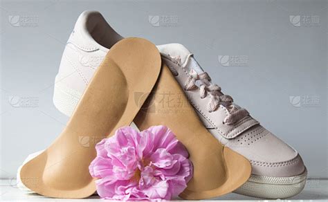 骨科鞋垫装饰与玫瑰臀花在运动鞋的背景。