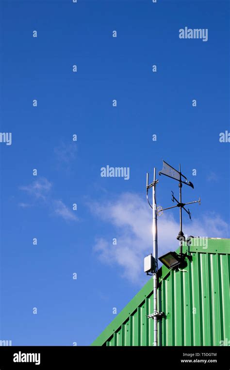 Metal Weather Vane Fixed To Top Of Building To Show Wind Direction With Letters Indicating The