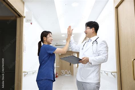병원 복도에서 간호사와 의사가 하이파이브를 하는 모습 Stock Foto Adobe Stock