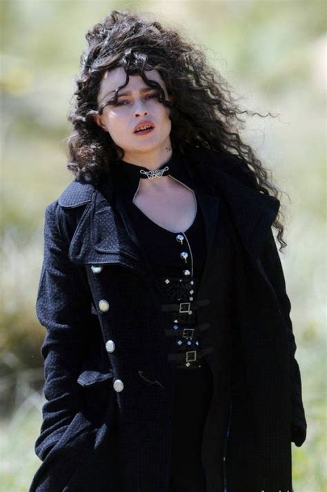 A Woman With Long Hair Wearing A Black Coat And Pearls On Her Face
