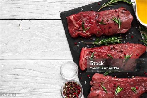 생고기 향신료 올리브 오일과 로즈 메리 나무 배경 위에 검은 슬레이트 절단 보드에 쇠고기 스테이크 고기에 대한 스톡 사진 및 기타 이미지 Istock