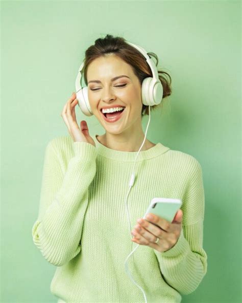 Happy Smiling Woman Listening To Music On Headphones And Holding A