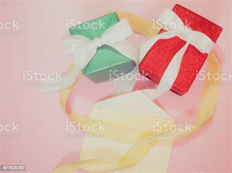 축 하 크리스마스 생일이 나 핑크 파스텔 배경에 넣어 새 해에 대 한 리본 장식으로 붉은 색과 녹색 빛나는 종이 아름다움 선물