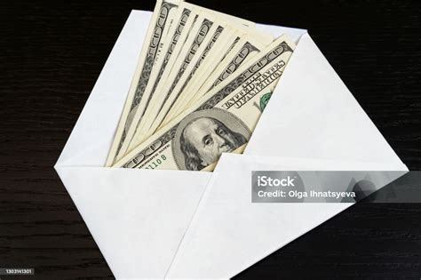 검은 색 테이블에 흰색 봉투에 미국 달러 클로즈업 소득 상여금 또는 뇌물의 개념 부패 임금 보너스 0명에 대한 스톡 사진 및