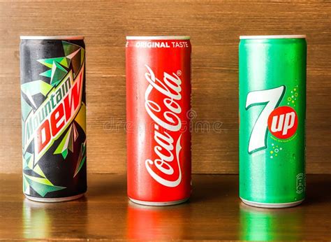 Assorted Soft Drink Cans With Coke 7up And Dew Isolated On Wooden