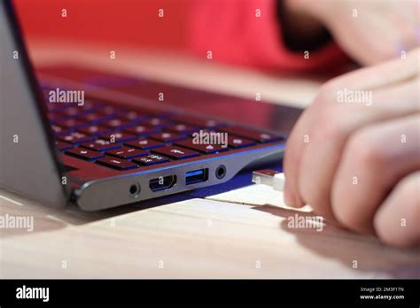 Inserting A Usb Cable Into A Laptop On A Table And Colored Background Stock Photo Alamy