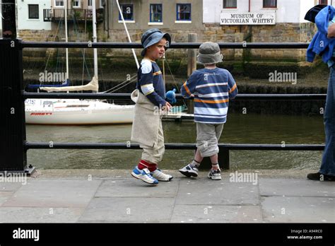 Two Young Lads On The Harbour Wall At Whitby North Yorkshire Stock
