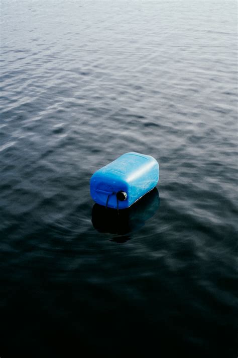 A Blue Object Floating On Top Of A Body Of Water Photo Free Water Image On Unsplash