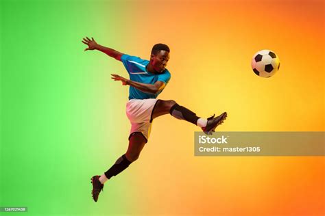 네온 빛에 그라데이션 스튜디오 배경에 고립 된 행동에 남성 축구 축구 선수 훈련 축구공에 대한 스톡 사진 및 기타 이미지