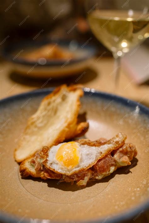 Vista Próxima De Um Croissant De Atum Vermelho Com Ovo E Um Copo De Vinho Foto Premium
