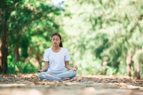 Premium Photo Young Woman Practicing Yoga In Lotus Position At Park