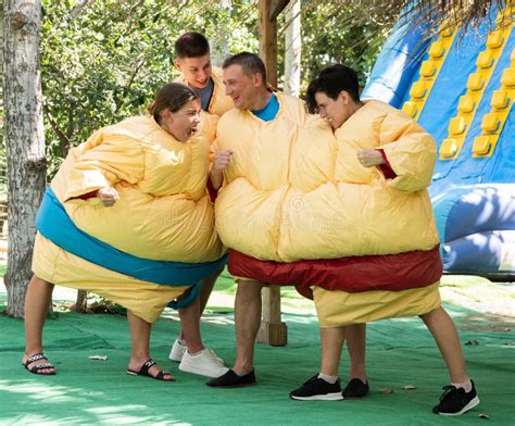 Cheerful Friends Having Fun On Fight Arena In Inflatable Sumo Twin